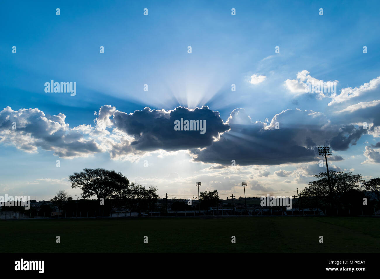 Sun behind clouds light rays blue sky Stock Photo - Alamy