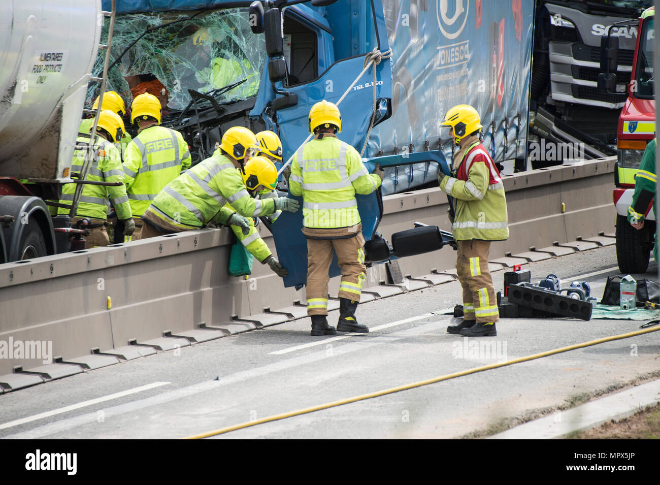 Four HGVs crash one man trapped fire service and ambulance crews trying to extracate him air ...