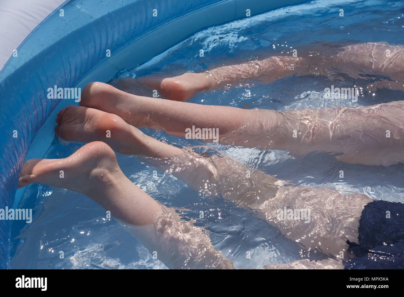 Inflatable paddling pool: two unidentifiable boys playing in an ...