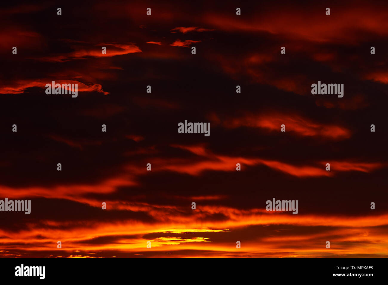 Red clouds at sundown like a burning sky of a spectacular sunset from ...