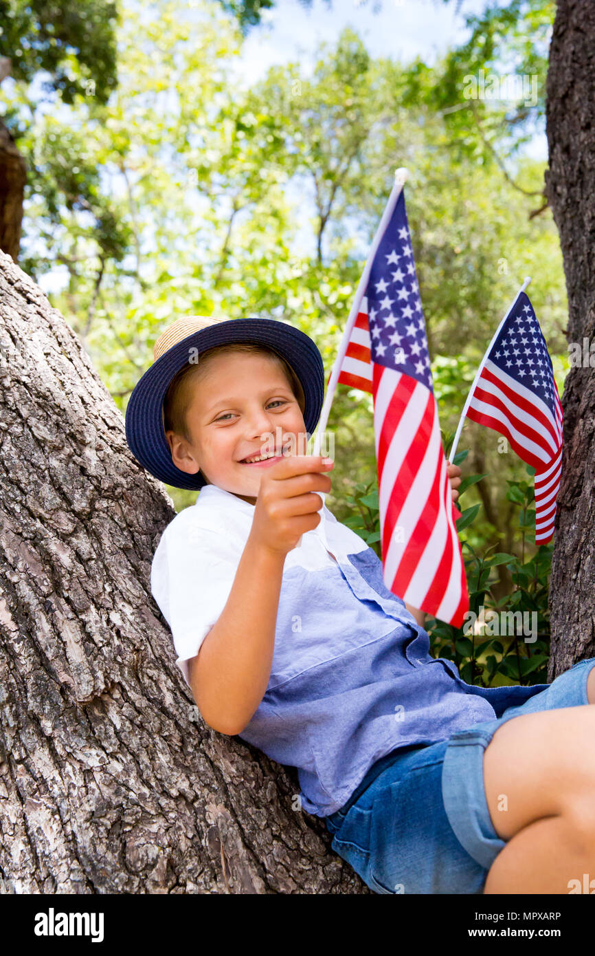 Adorable little boy holding american flag outdoors on beautiful summer ...