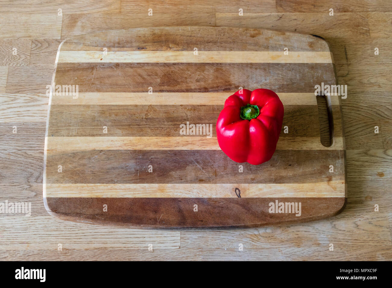 A red pepper on a chopping board Stock Photo - Alamy