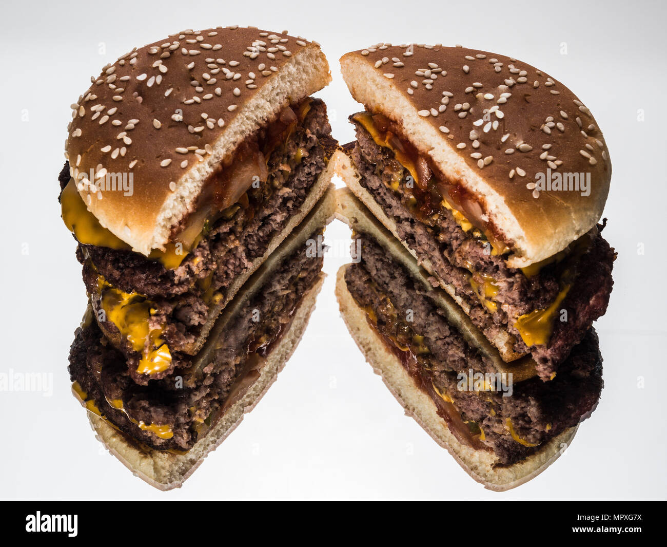 double pattie hamburger cut in half on mirror Stock Photo - Alamy