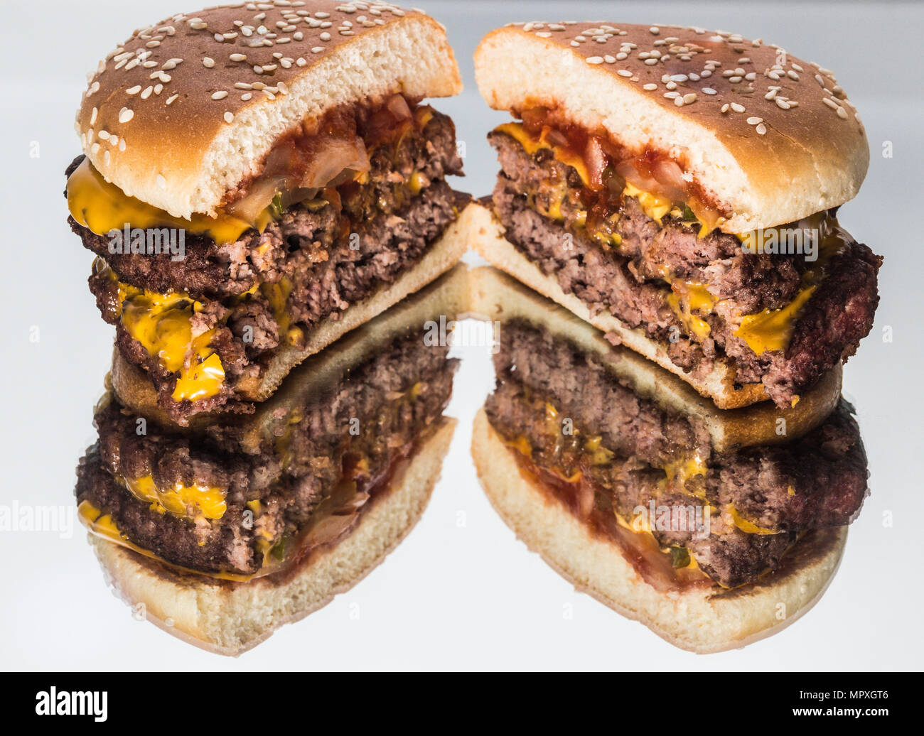 double pattie hamburger cut in half on mirror Stock Photo - Alamy