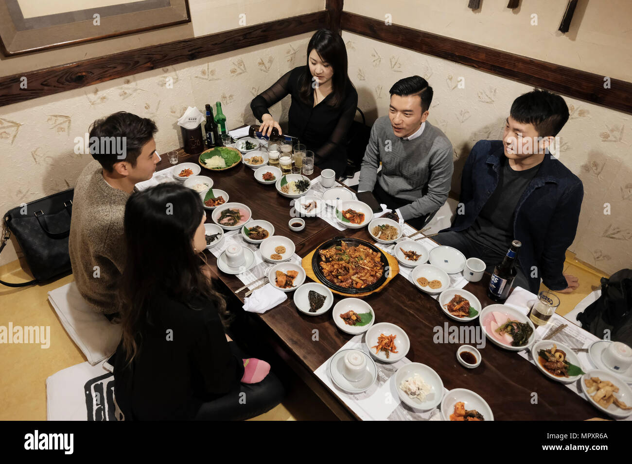 Young Korean people sitting in a restaurant serving traditional Korean ...