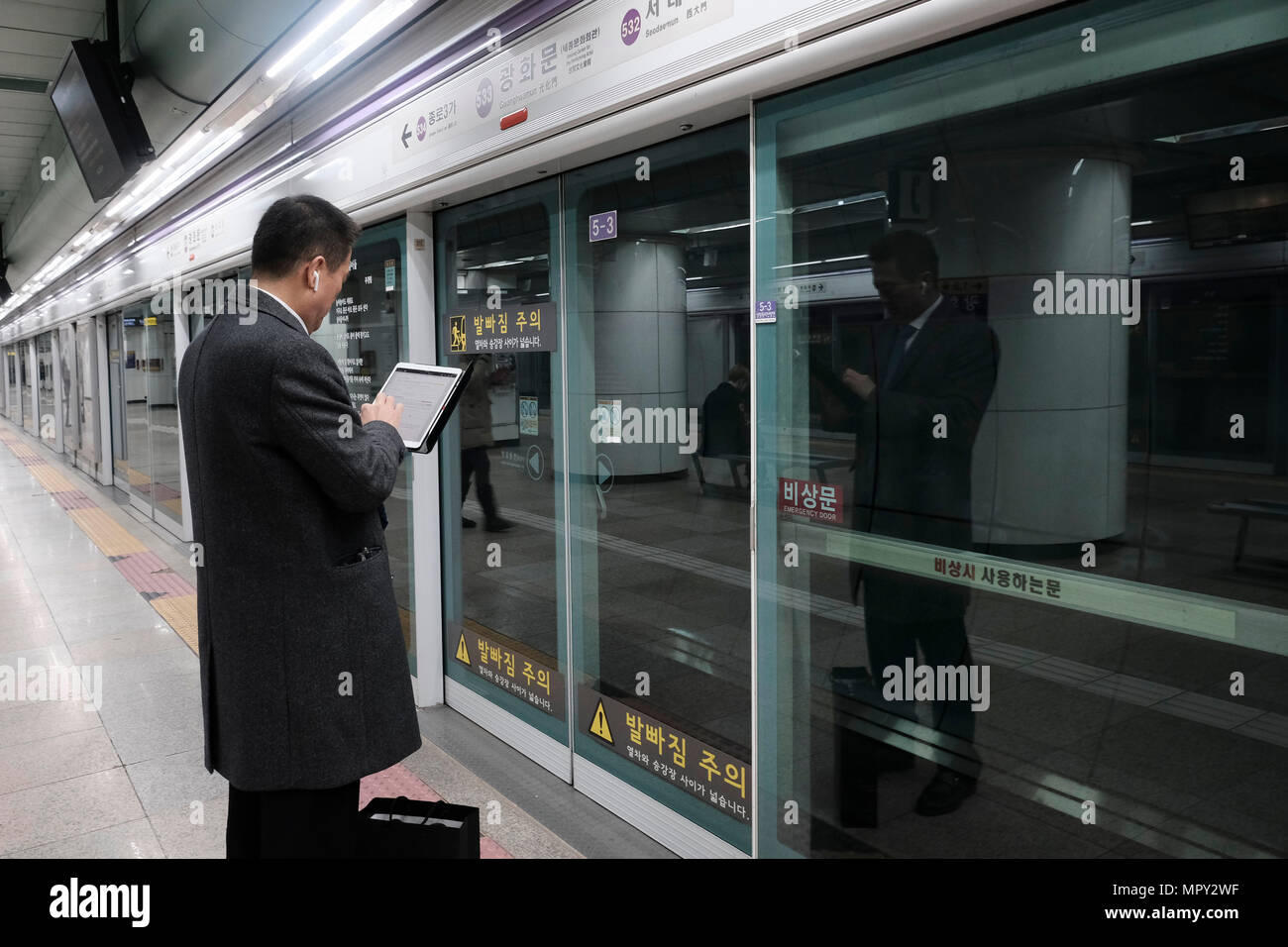 A Korean man using a tablet computer in Gwanghwamun Station of the ...