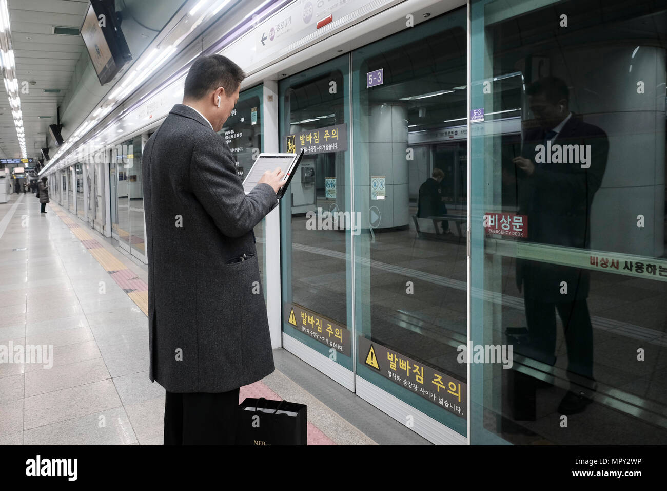 A Korean man using a tablet computer in Gwanghwamun Station of the ...