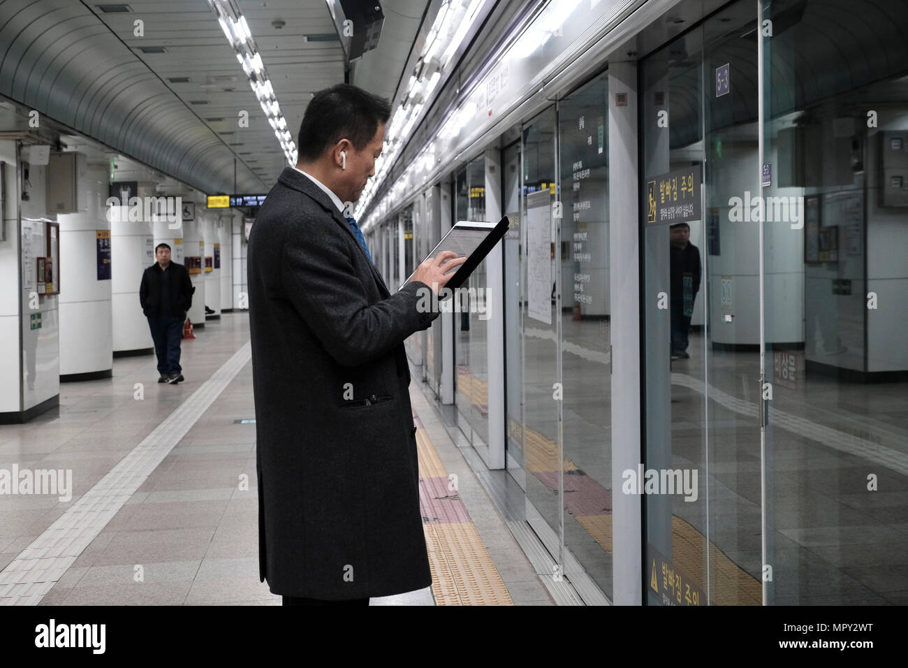 A Korean man using a tablet computer in Gwanghwamun Station of the ...