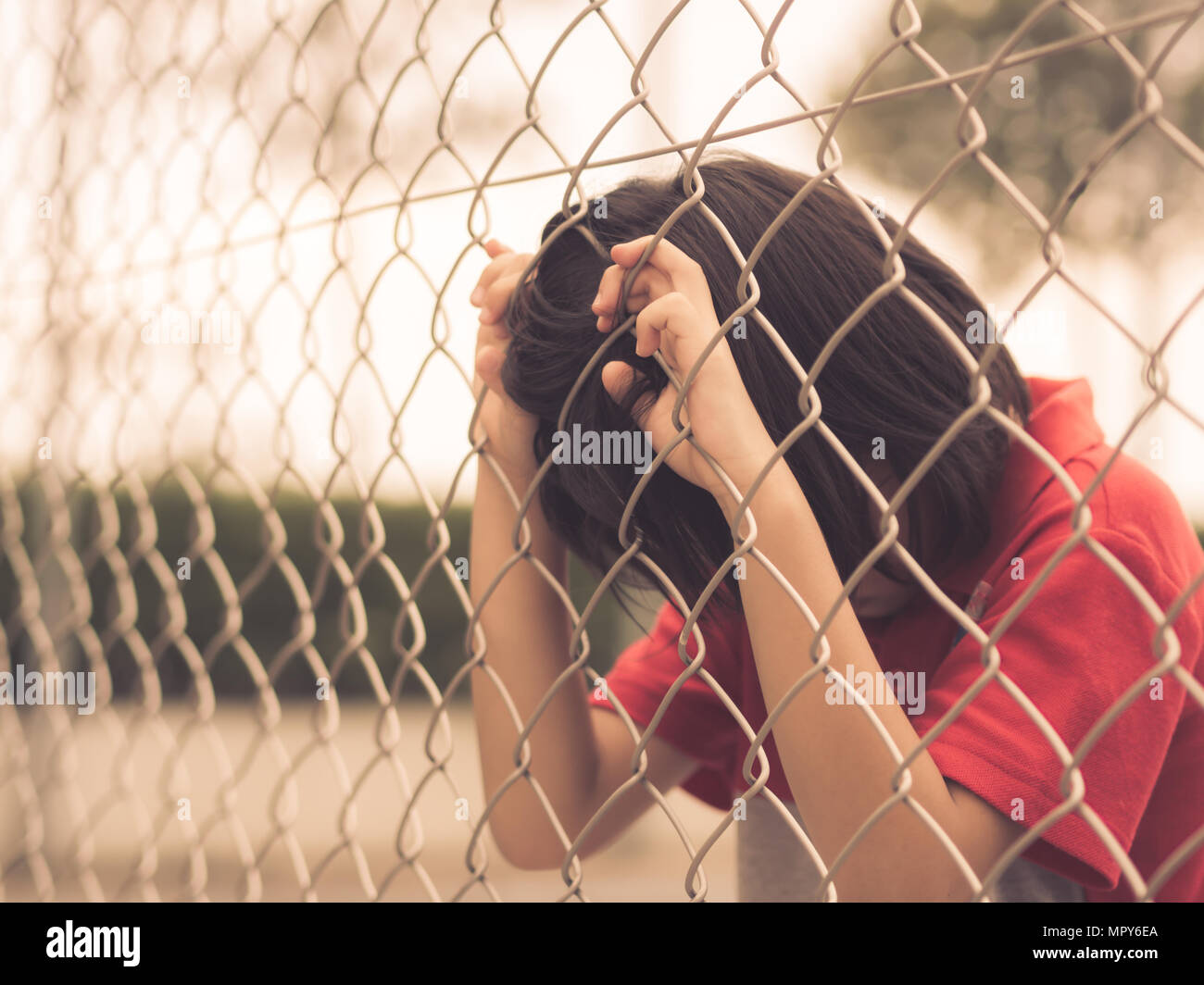 Boy behind wire fence hi-res stock photography and images - Alamy