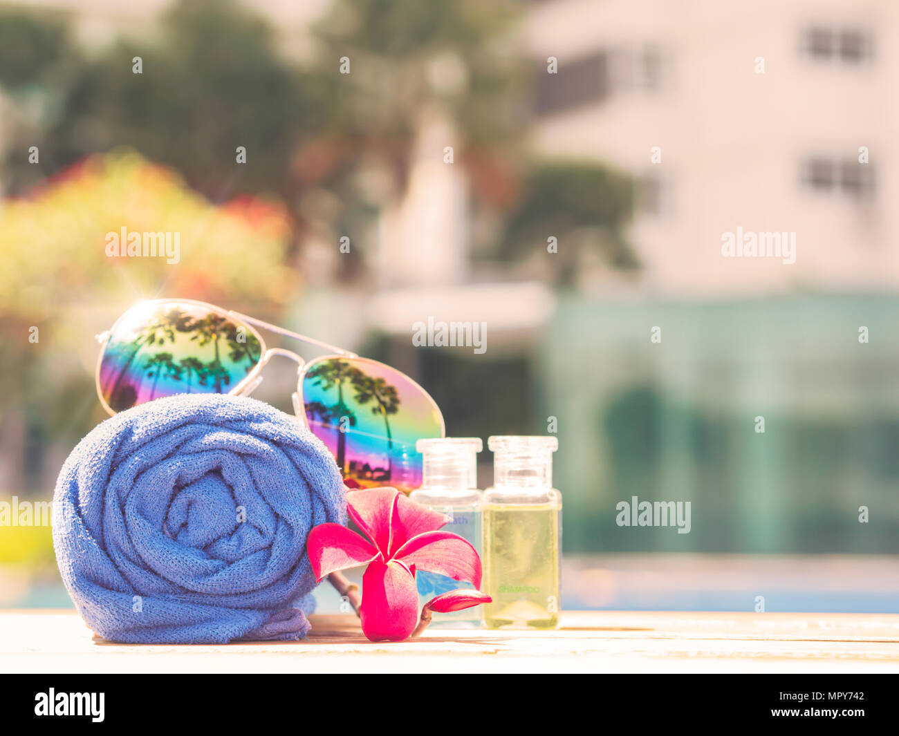 Retro style of sungrasses, shampoo, lotion and rolled up towels at the ...