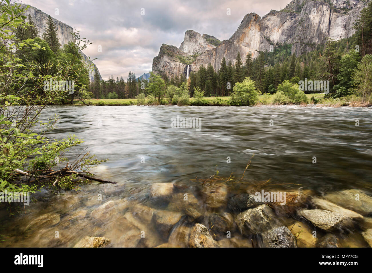 Scenic view of river by mountains against cloudy sky at Yosemite ...
