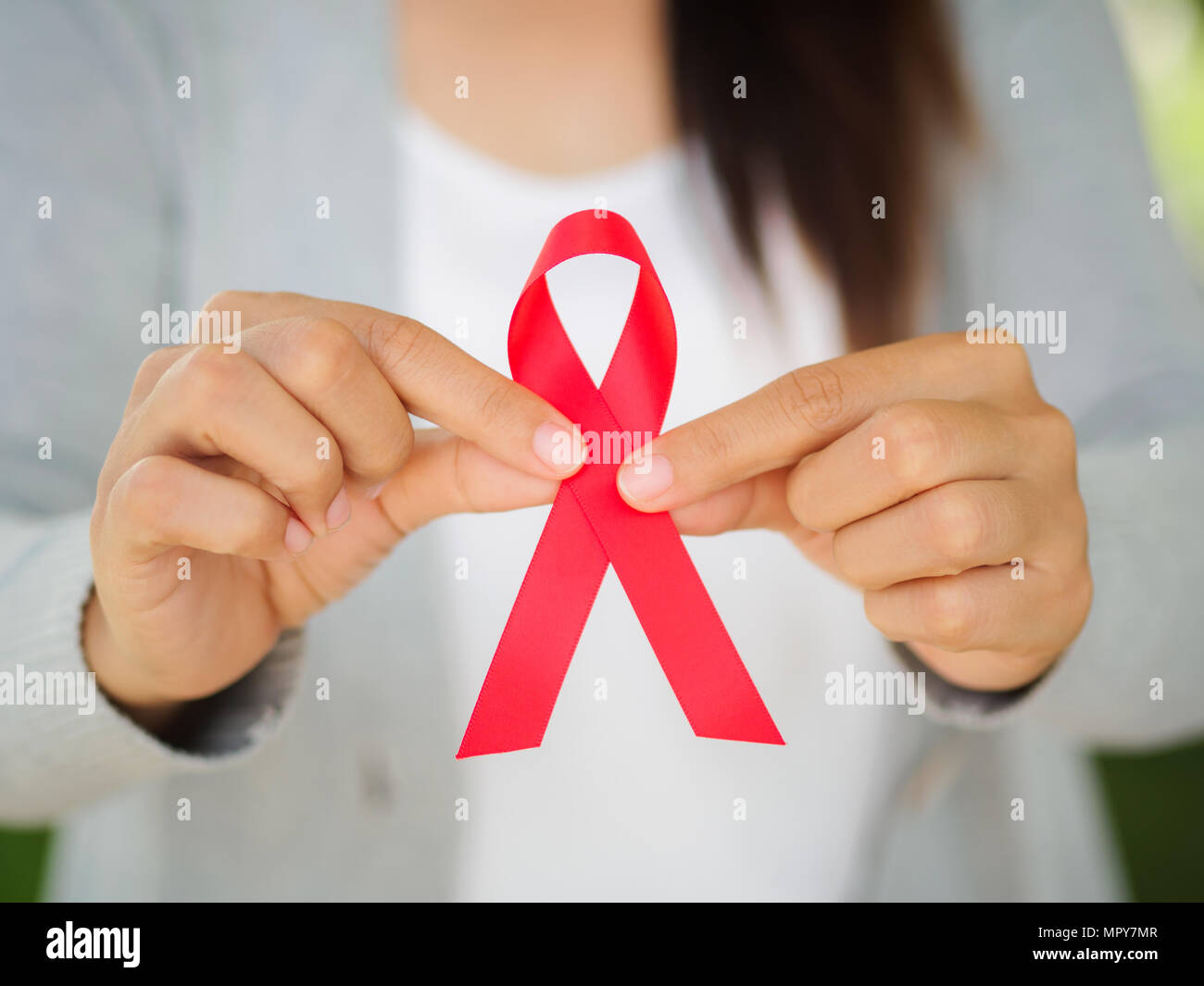 Woman hand holding red ribbon HIV, world AIDS day awareness ribbon ...