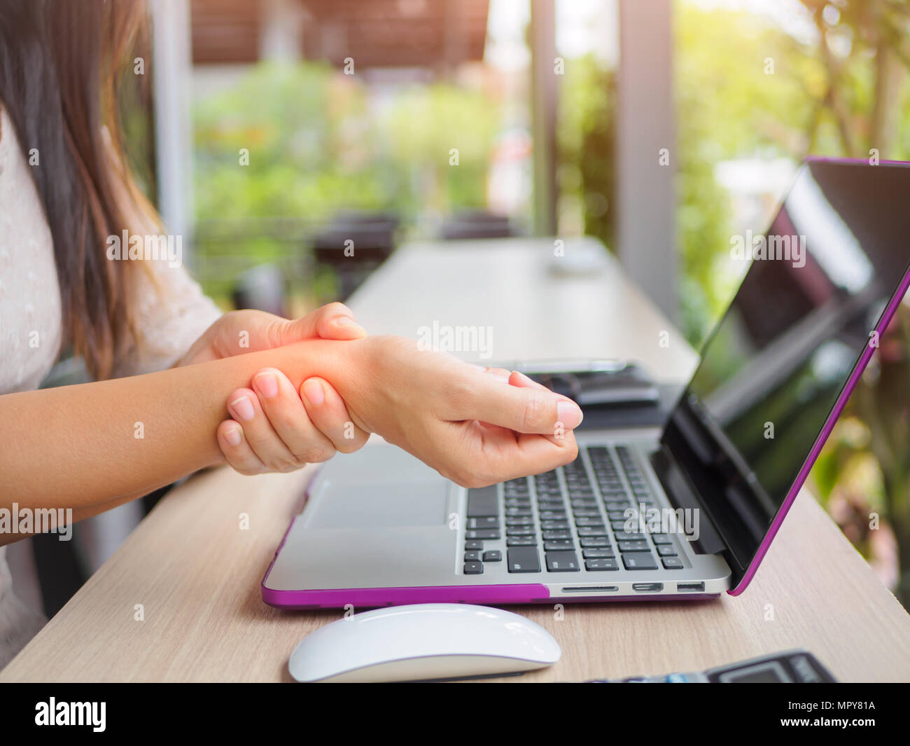 Closeup woman holding her wrist pain from using computer. Office ...