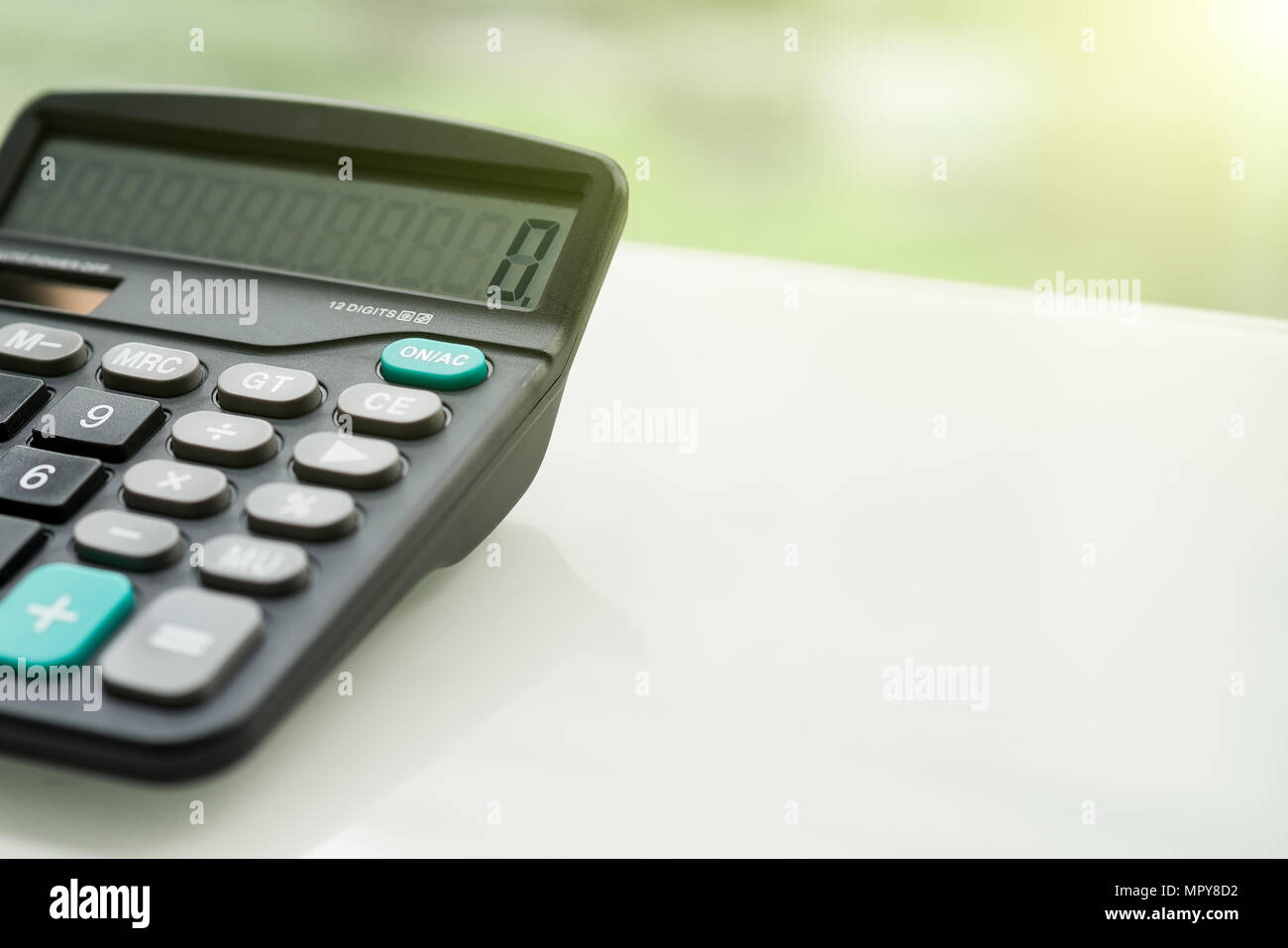Calculator on the white table near window, closeup sideview isolated ...