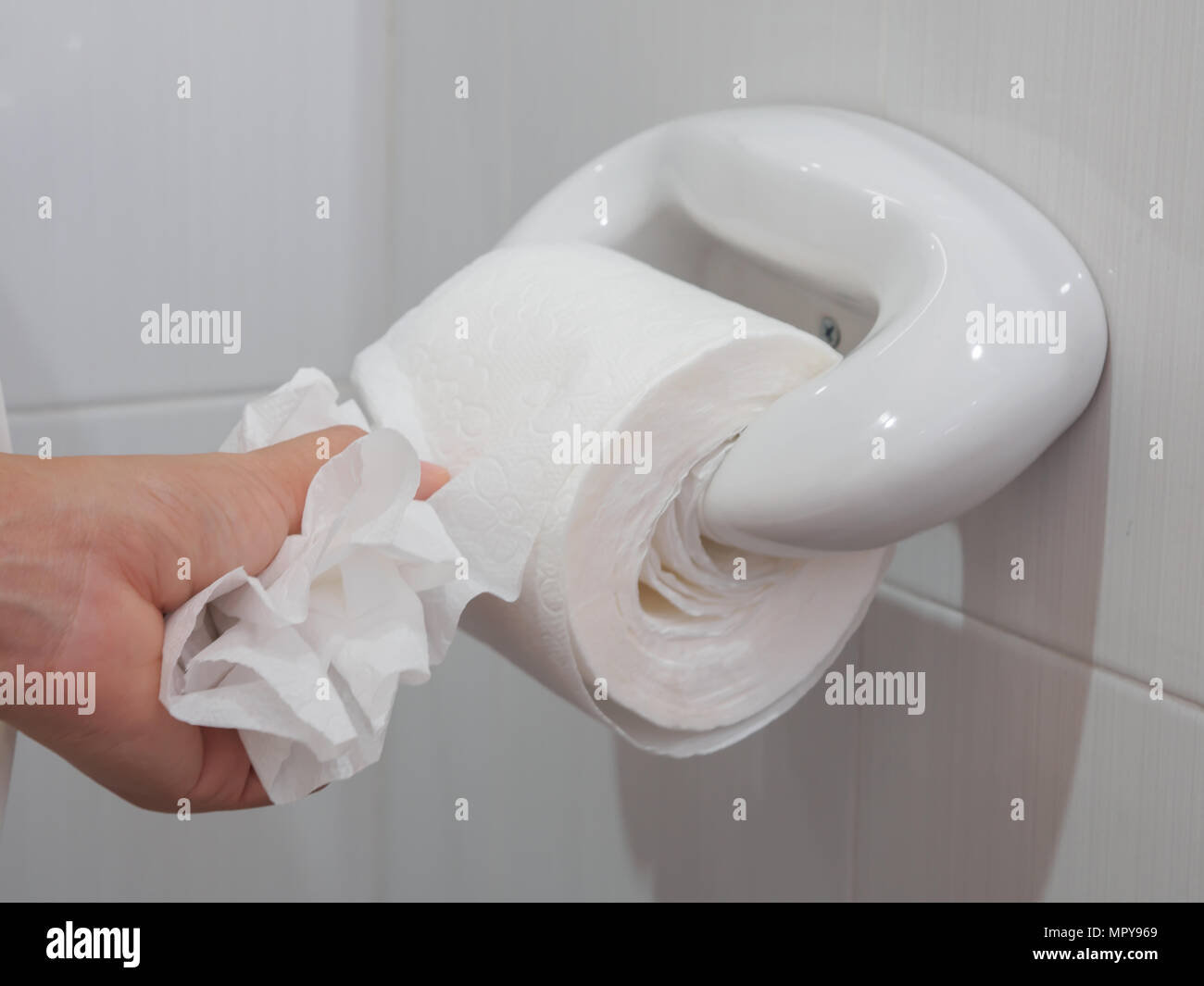 Soft focus female hand picking a white tissue from tissue roll in the ...