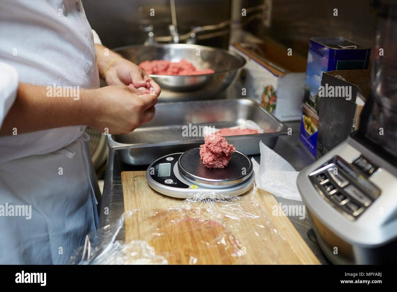 Midsection of chef measuring beef on weight scale in commercial kitchen ... Midsection of chef measuring beef on weight scale in commercial kitchen ...