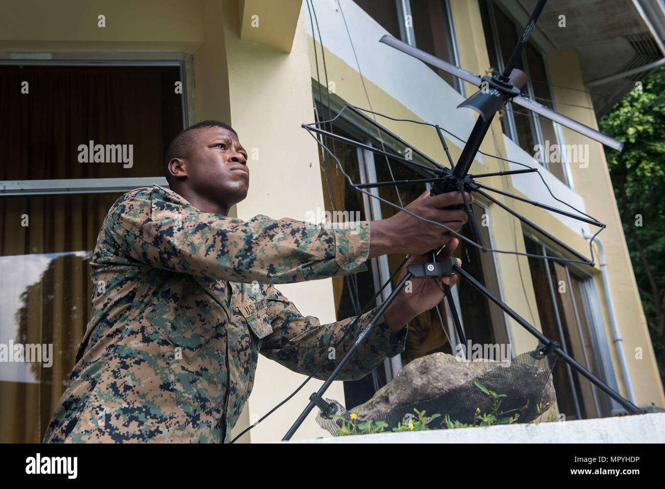 U.S. Marine Staff Sgt. Alexander Davis adjusts a satellite ...