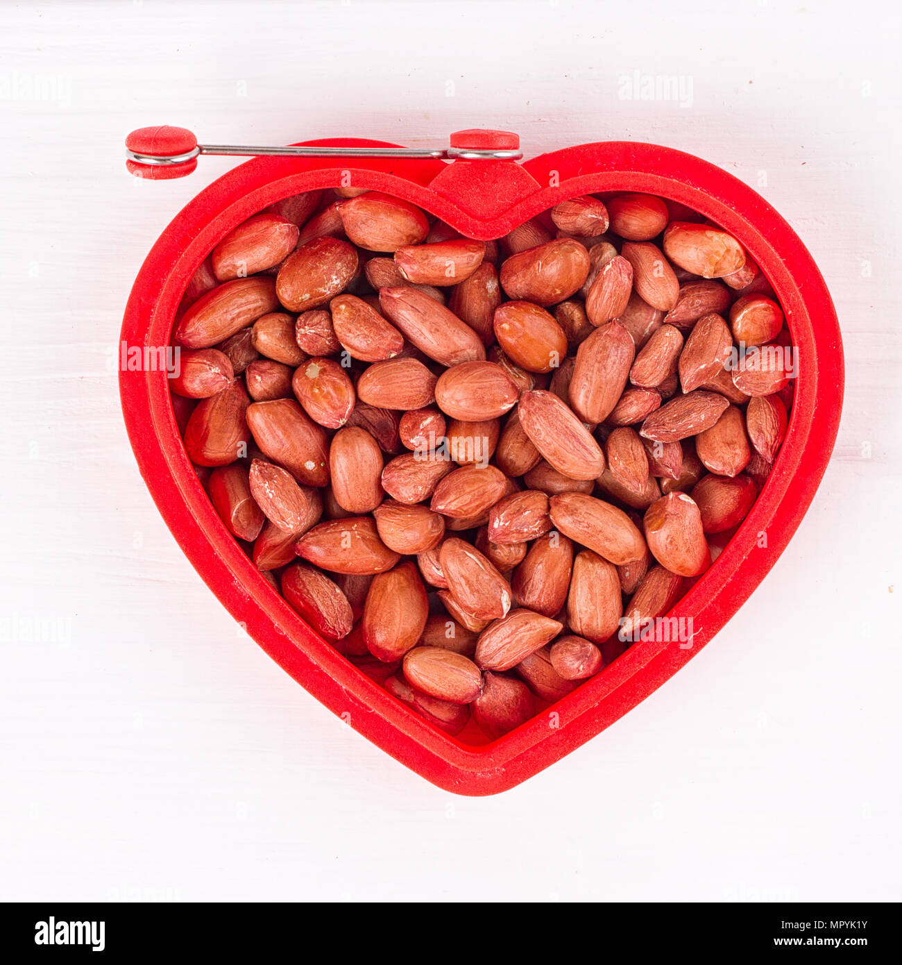 Raw peanuts in heart bowl on the white background Stock Photo - Alamy