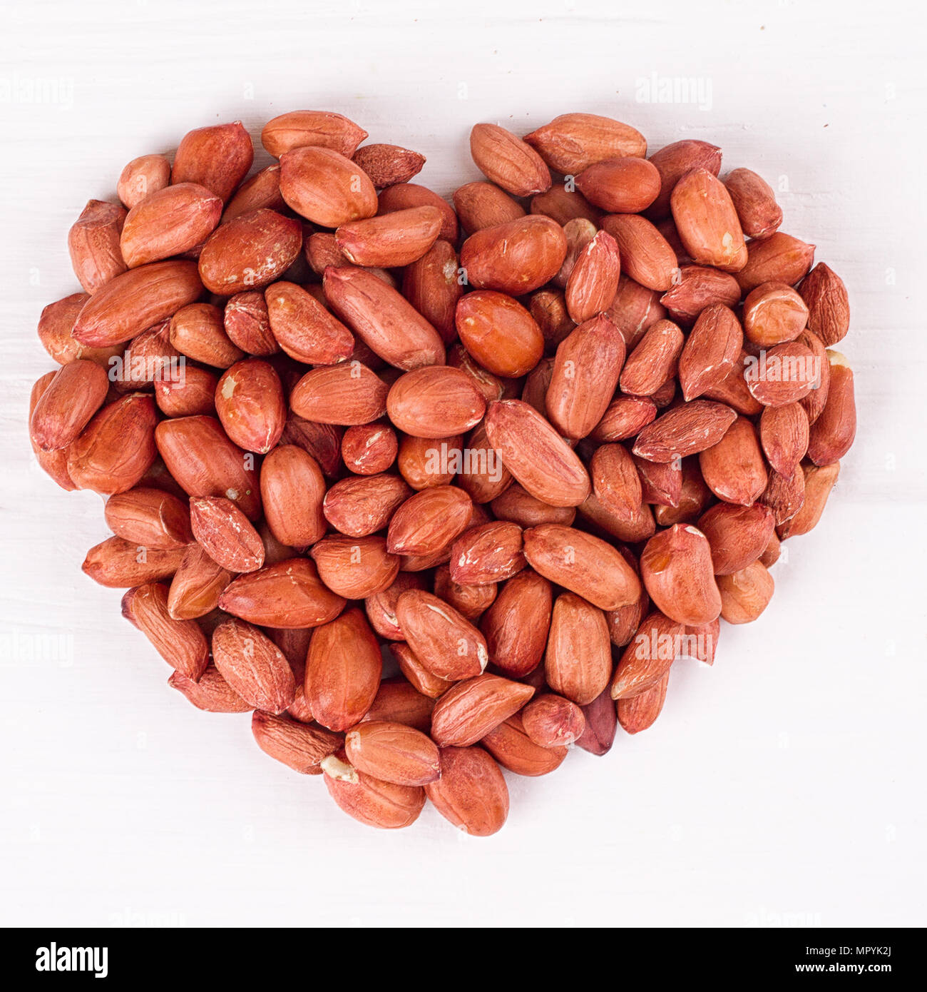 Peanuts in heart symbol isolated on white Stock Photo - Alamy
