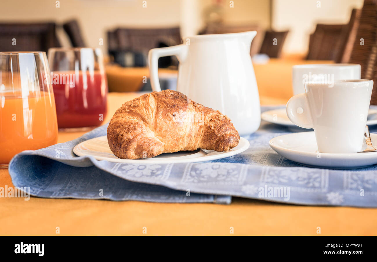 Sweet breakfast. Glasses of juice, croissant, jug of milk and coffee ...