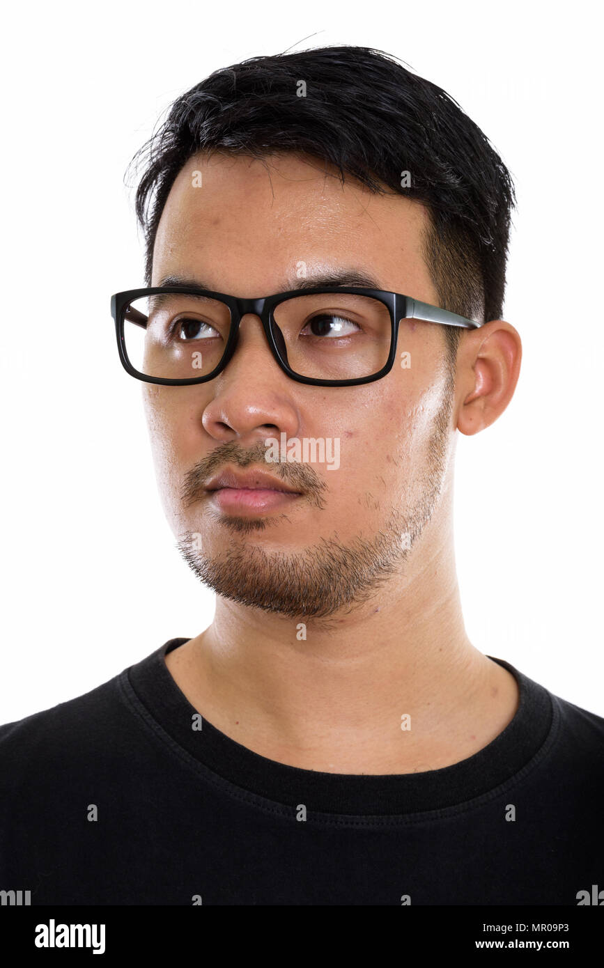 Face of young Asian man thinking while looking at distance and w Stock ...