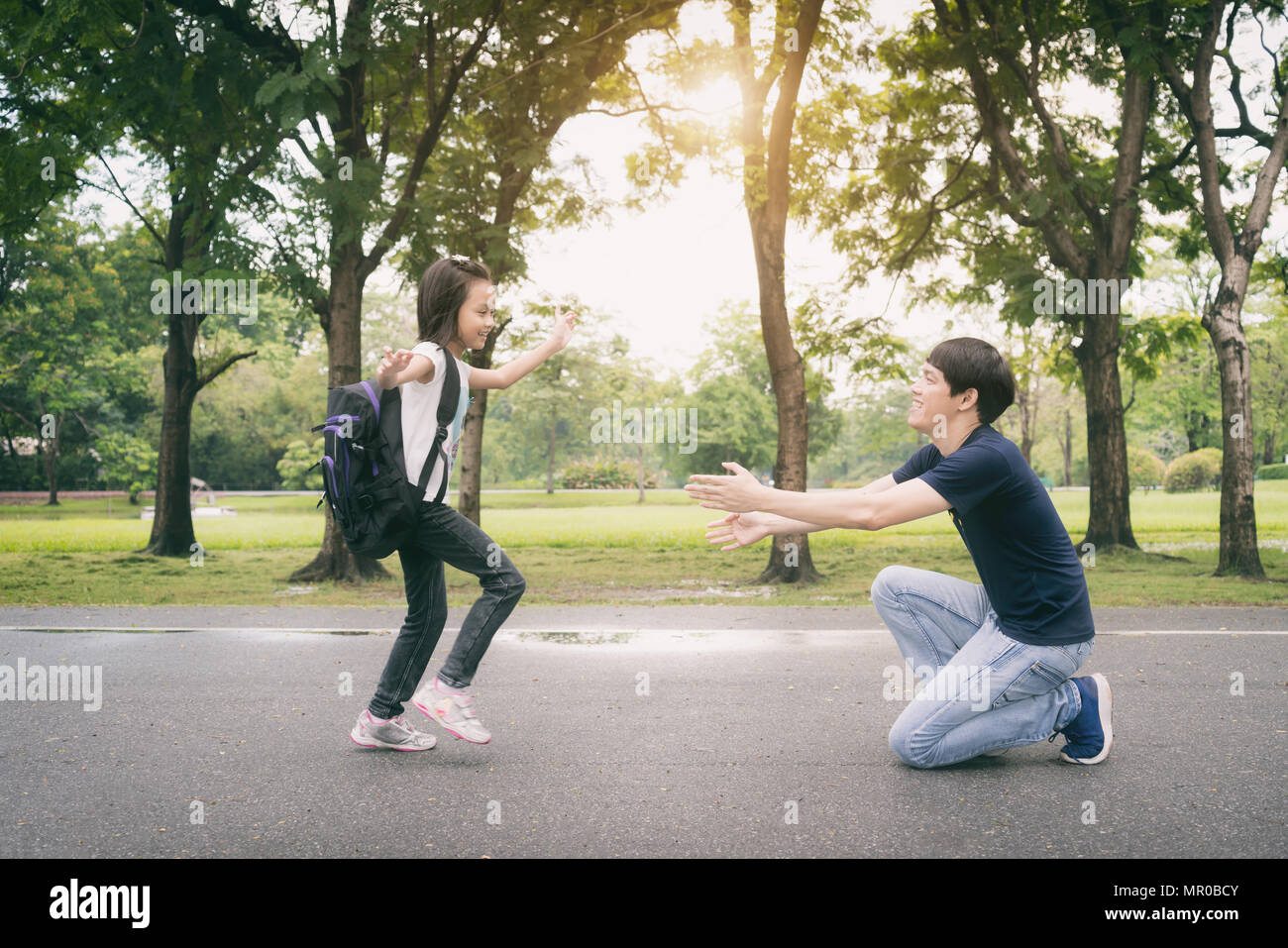 Asian girl kids student run into father’s hands to hug her after back ...