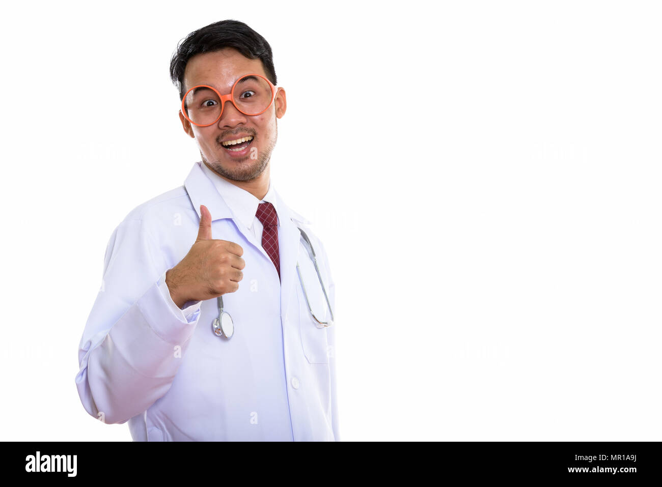 Studio shot of young happy Asian man doctor smiling while giving Stock ...
