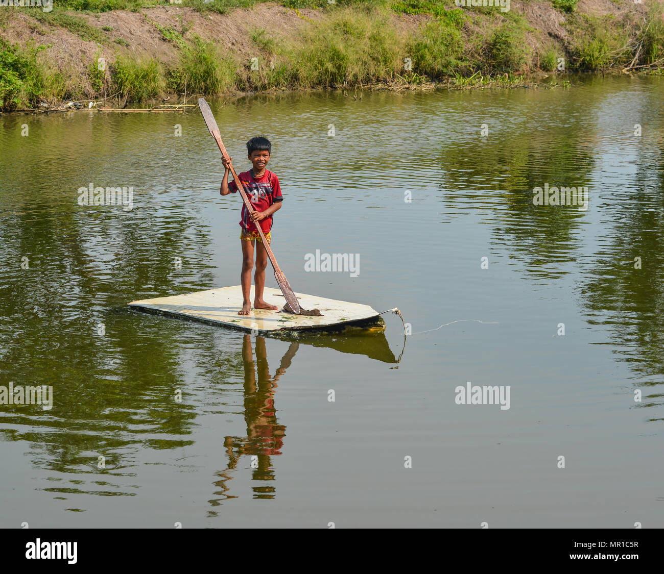 Bangkok, Thailand - Apr 23, 2017. A poor boy rowing boat on channel ...