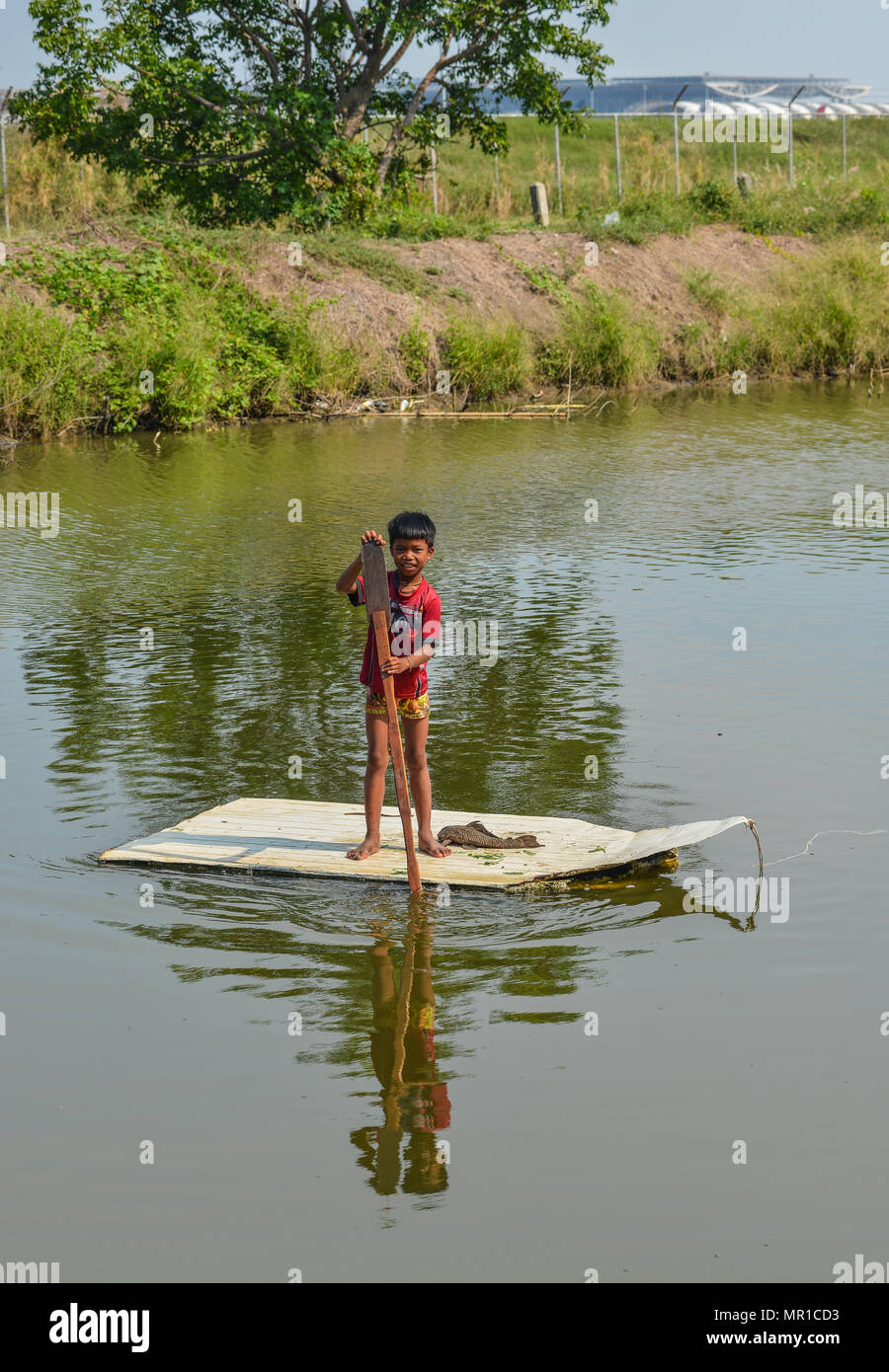 Bangkok, Thailand - Apr 23, 2017. A poor boy rowing boat on channel ...
