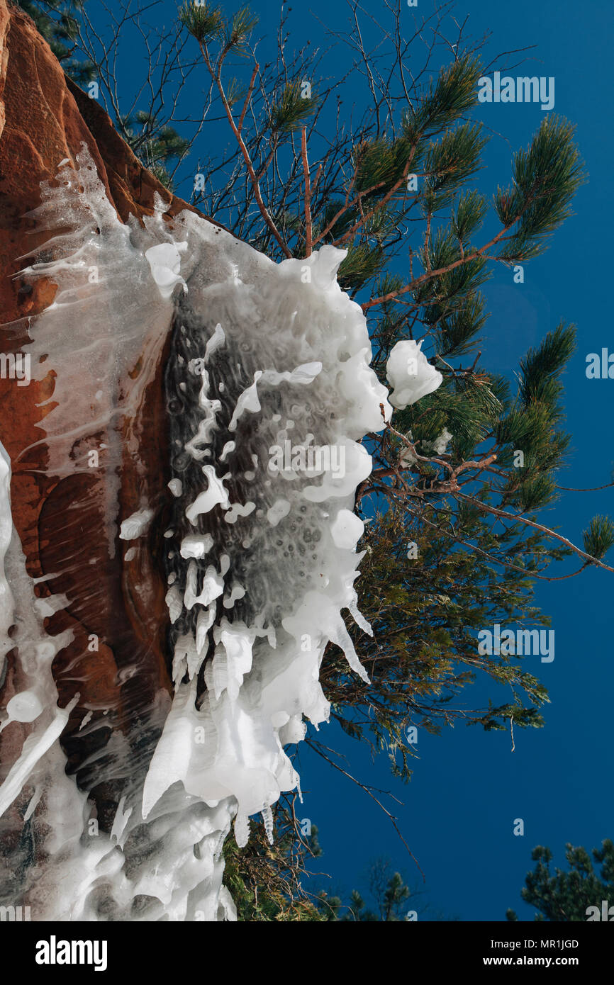 Red rock caves are ice covered along the shoreline of the Apostle ...