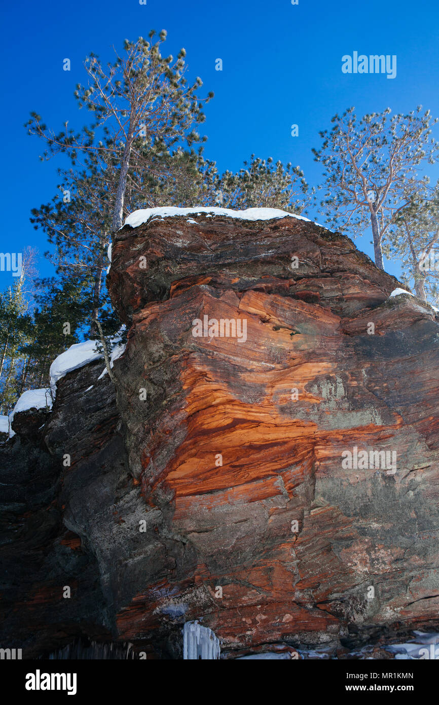 Red rock caves are ice covered along the shoreline of the Apostle ...