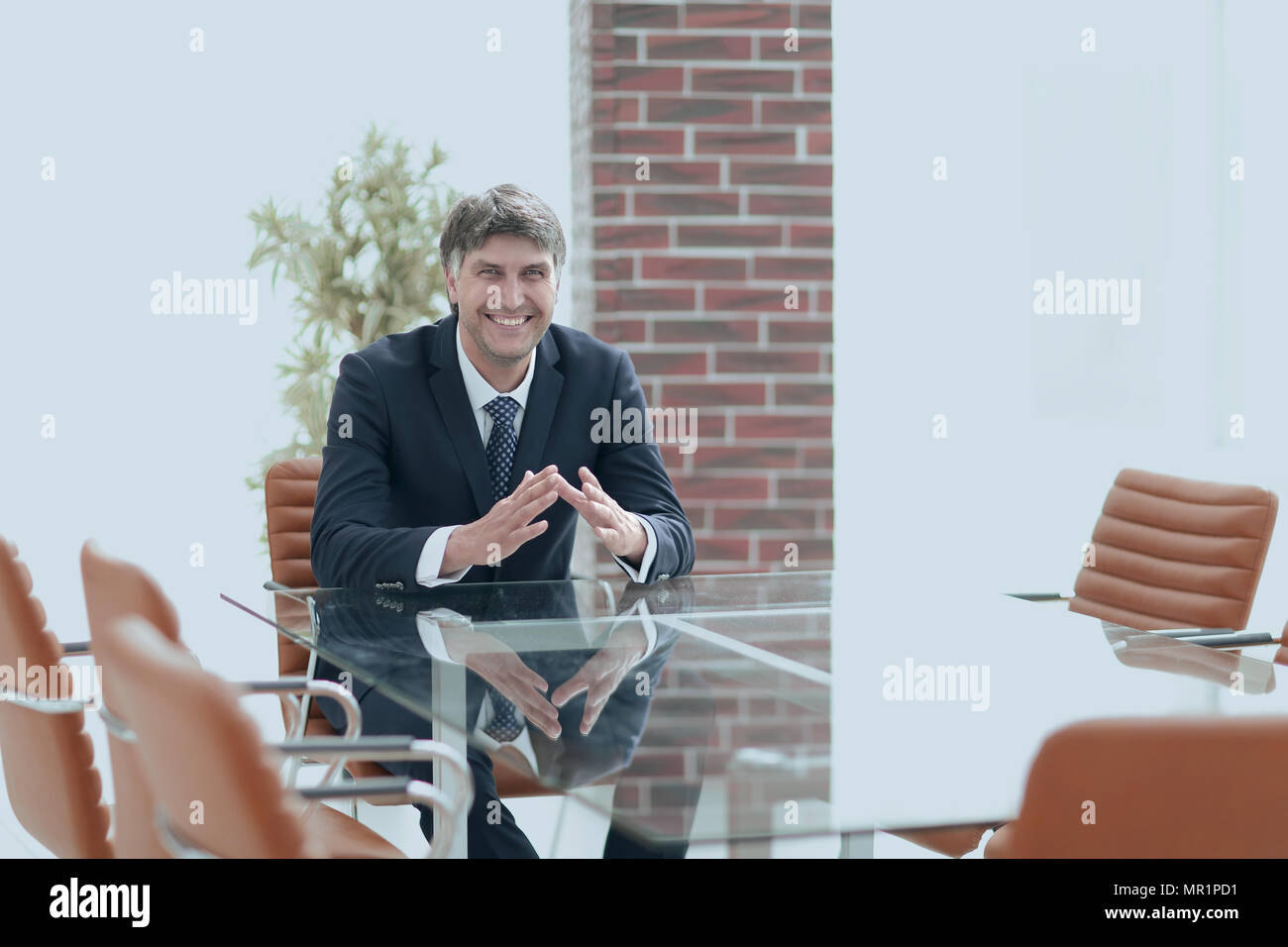 Project manager sitting at a table in an empty conference room Stock ...