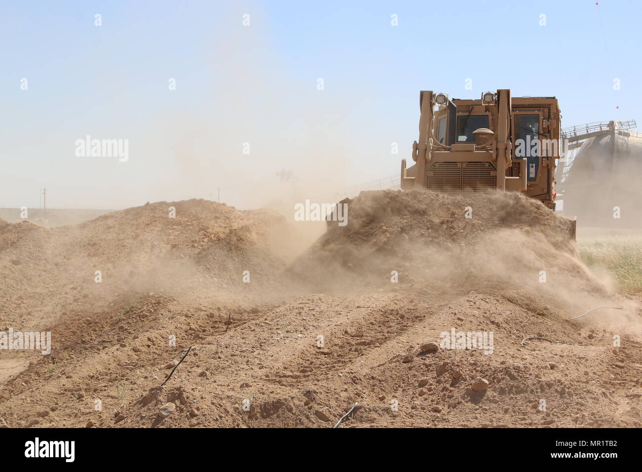 An Iraqi federal police member drives a bulldozer during a training ...