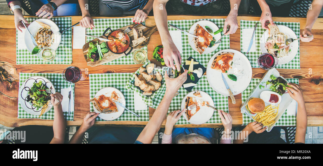 eating and leisure concept - group of people having dinner at table ...