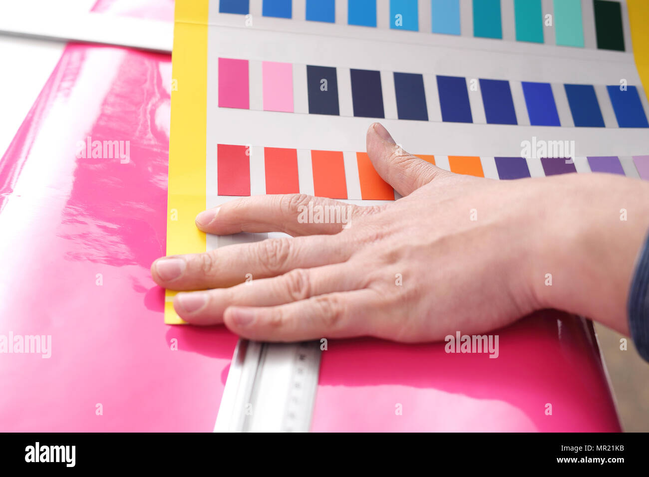 Paint color sampler. The man compares the color Stock Photo - Alamy