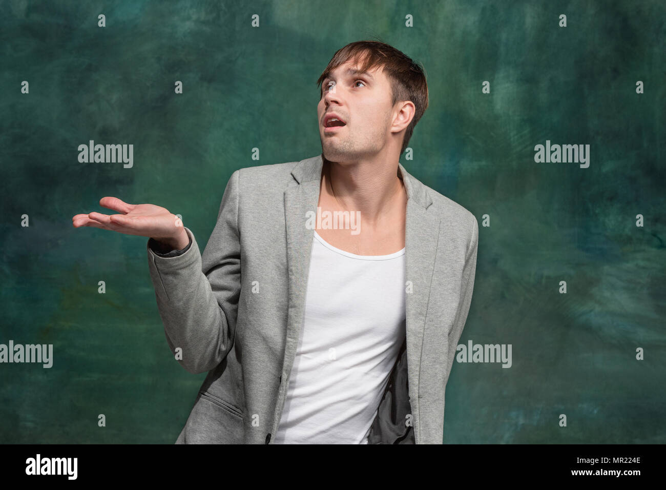 The happy man standing and smiling against studio background Stock ...