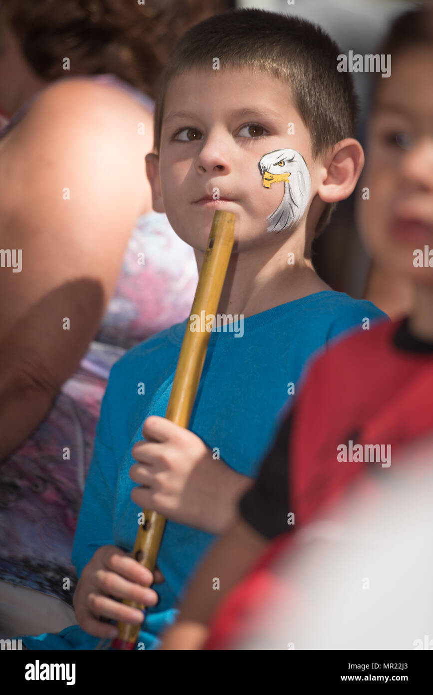 A young native american boy with a recorder and face painted at the ...
