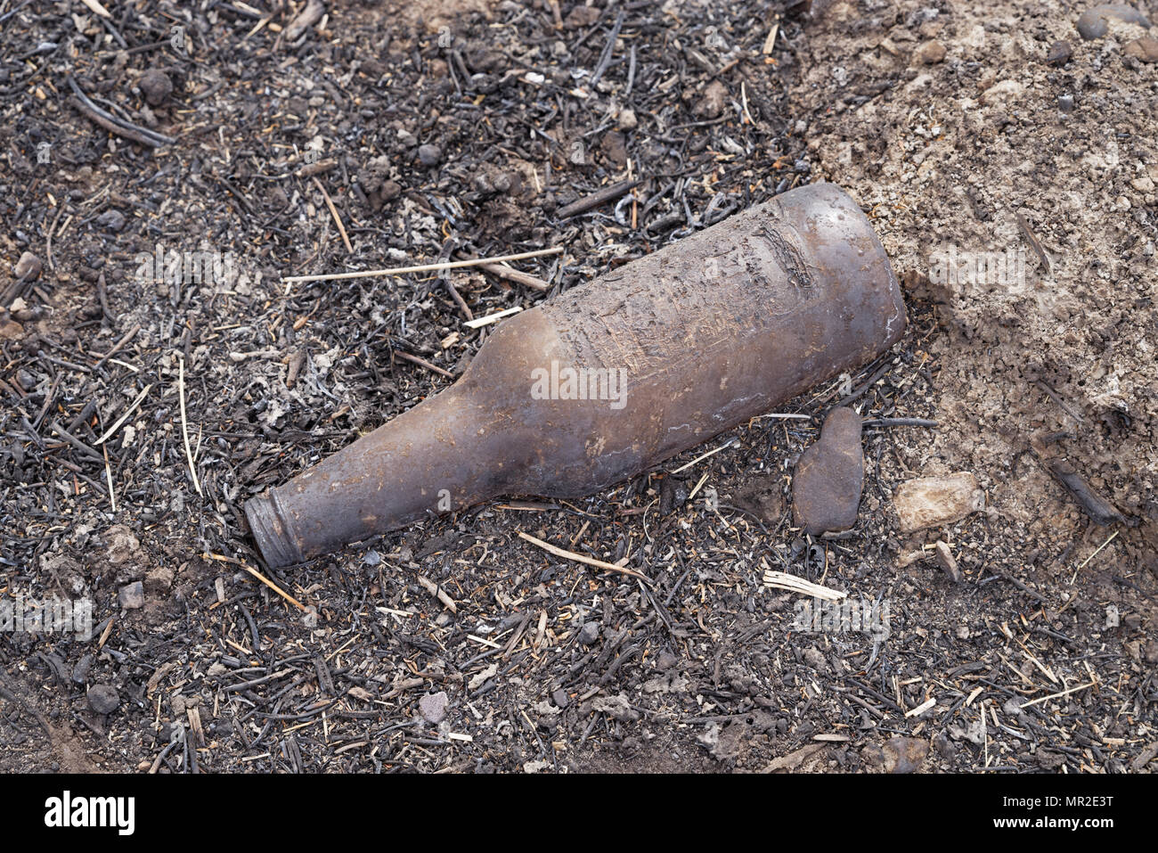 burned beer bottle litter revealed after a wildfire Stock Photo - Alamy