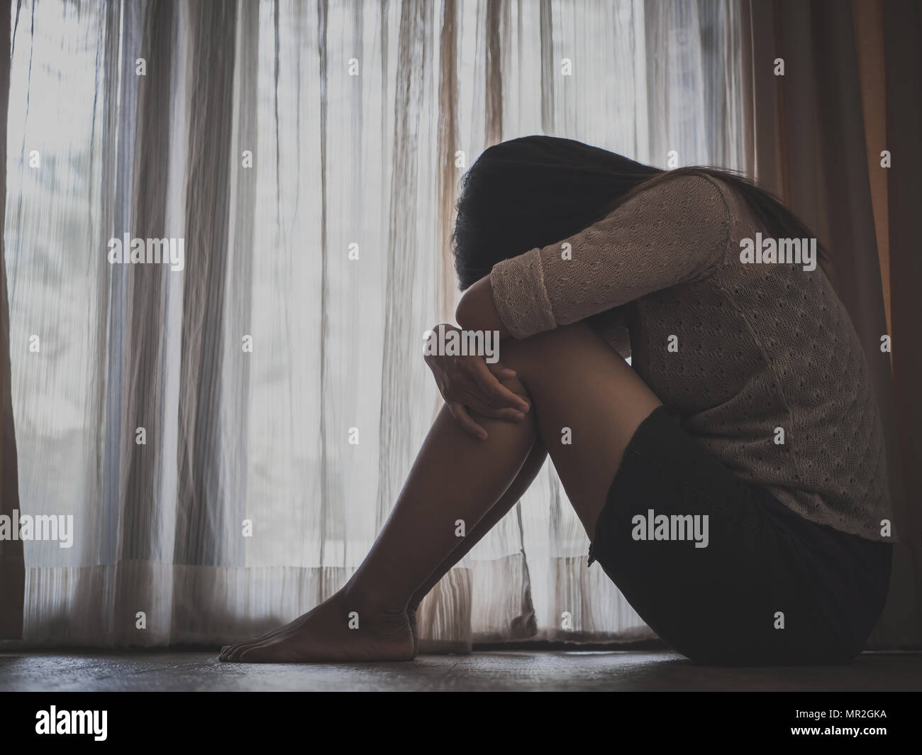 Sad Woman Hug Her Knee And Cry While Sitting Alone In A Empty Room