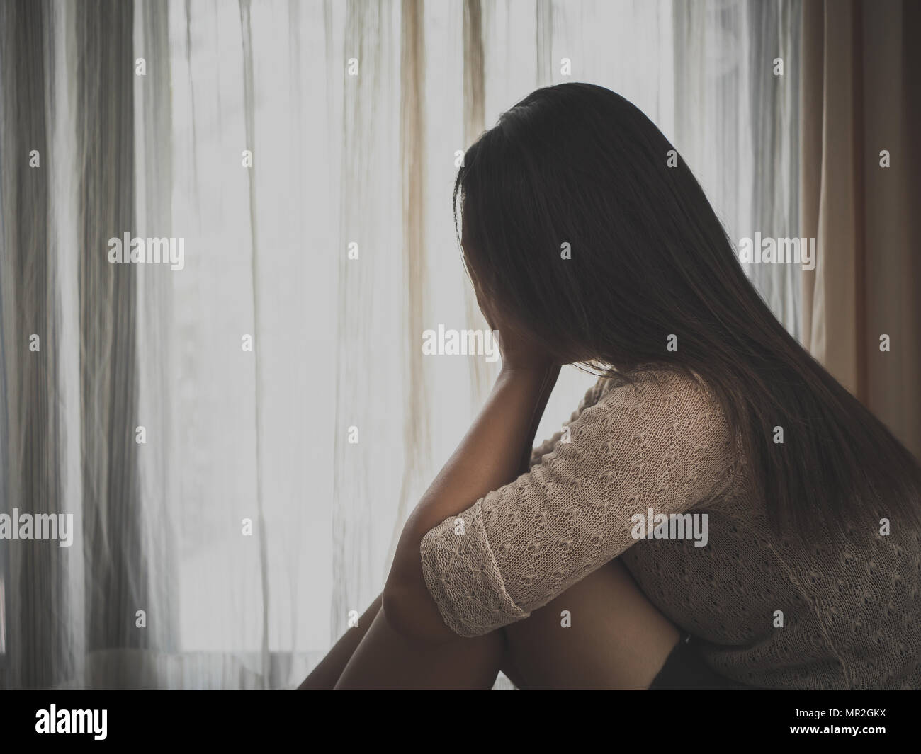 Sad Woman Hug Her Knee And Cry While Sitting Alone In A Empty Room