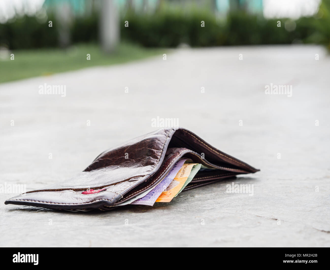 Lost leather wallet with money drop on sidewalk , lost money concept ...