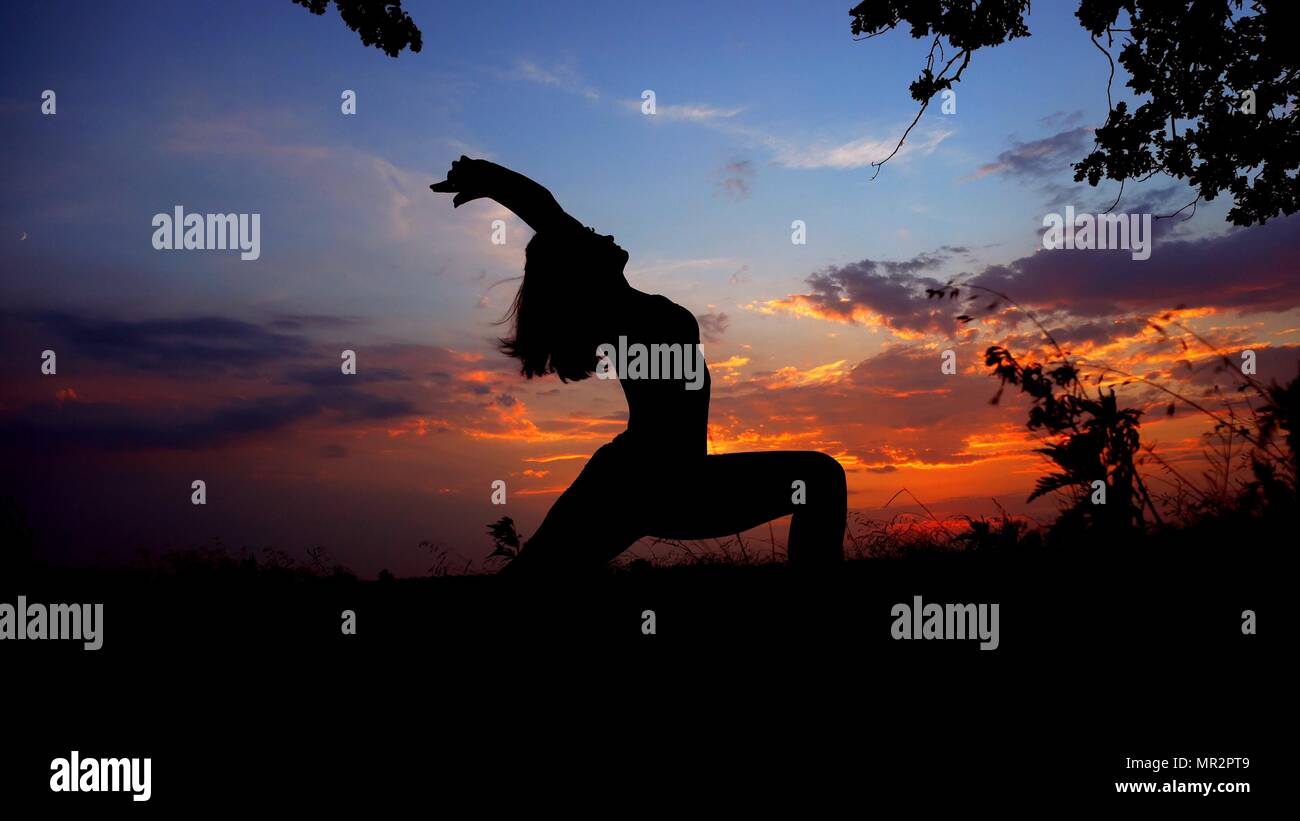 Woman shadow silhouette in evening sky background, yoga asana. Concept ...