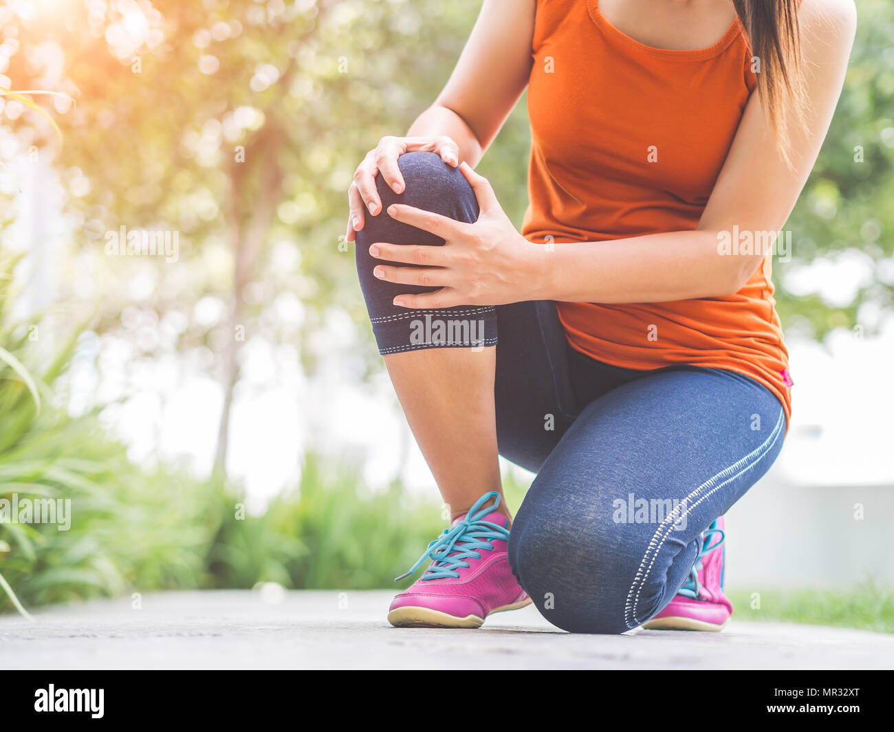 Runner sport knee injury. Woman in pain while running in the garden ...