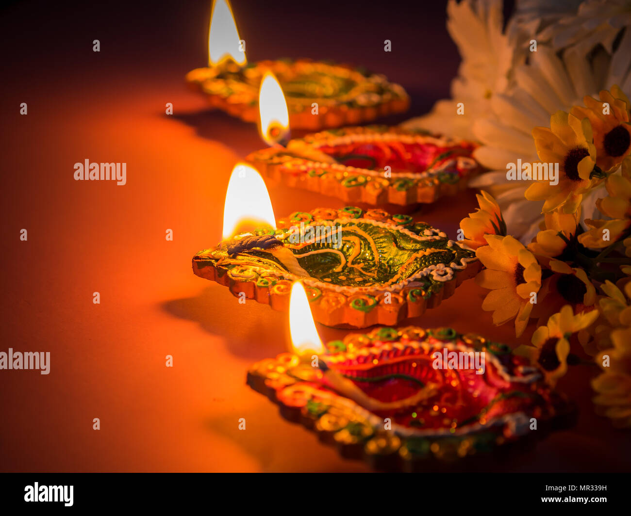 Colorful clay diya lamps lit with flowers for the Hindu Diwali festival ...