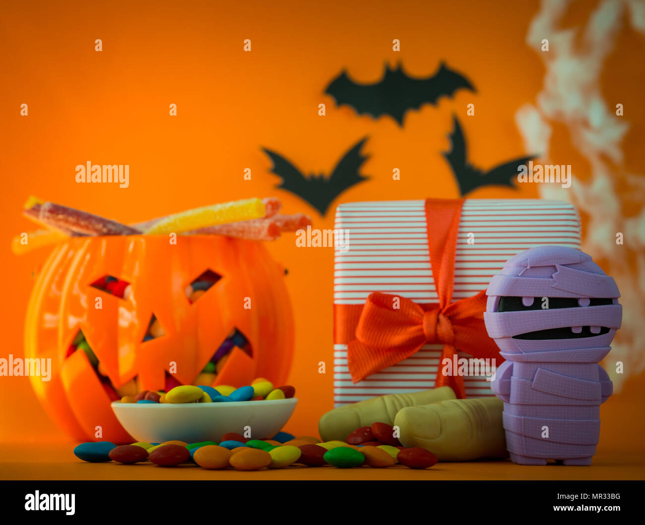 Happy Halloween decorations and candies on orange background Stock ...