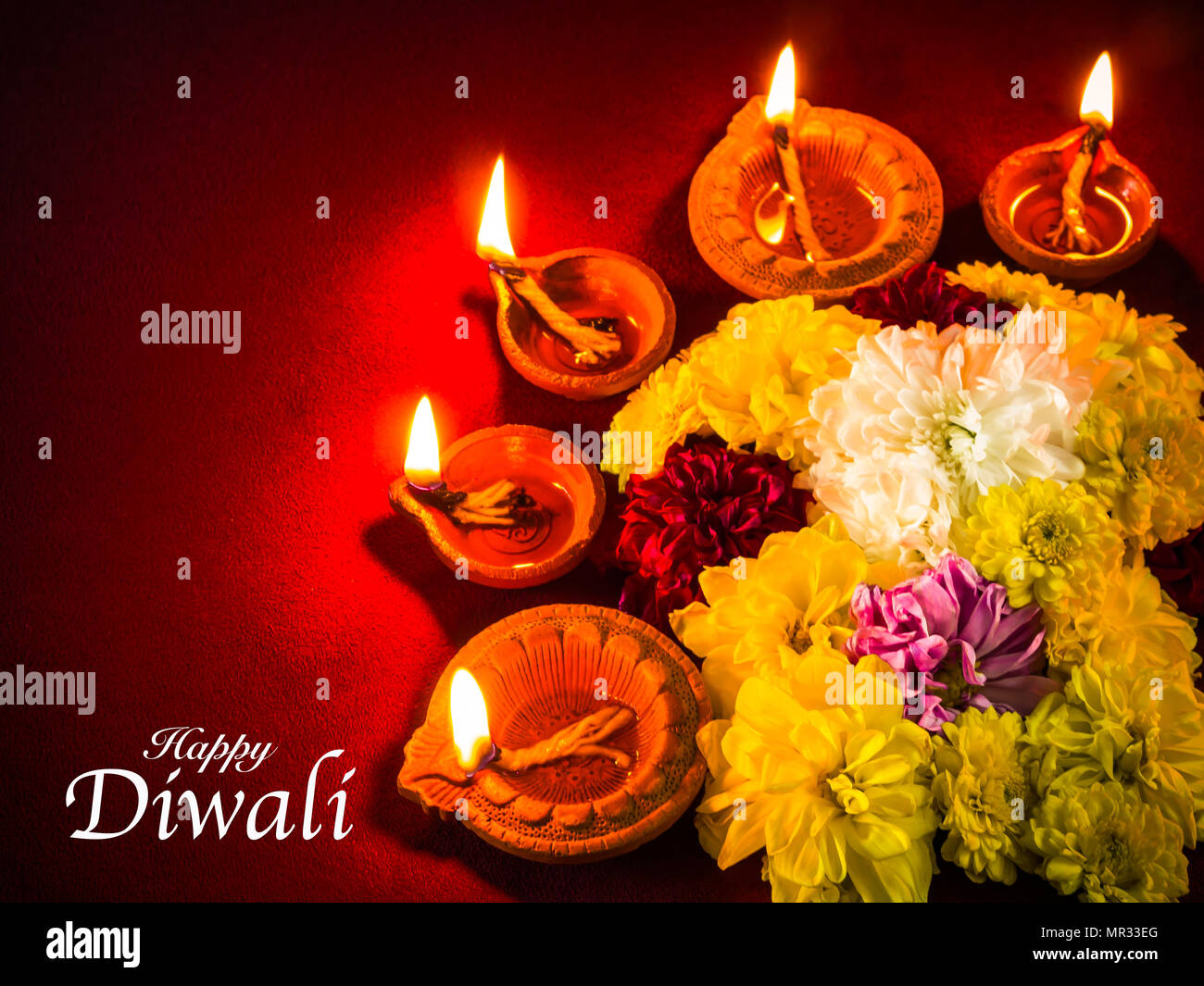 Traditional clay diya lamps lit with flowers for Diwali festival ...