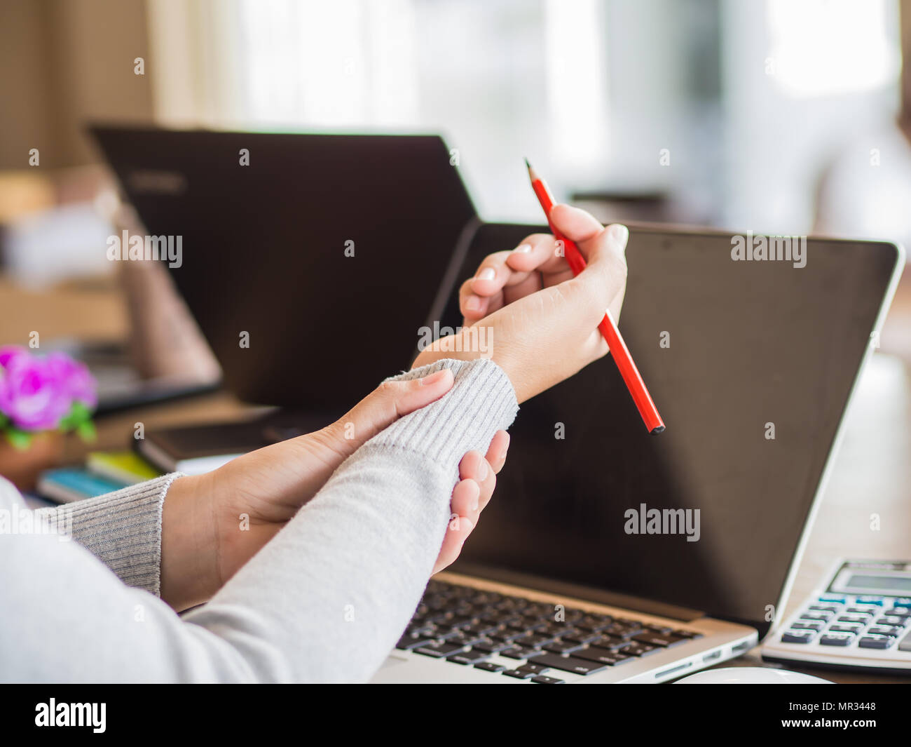 Closeup woman holding her wrist pain from using computer long time ...