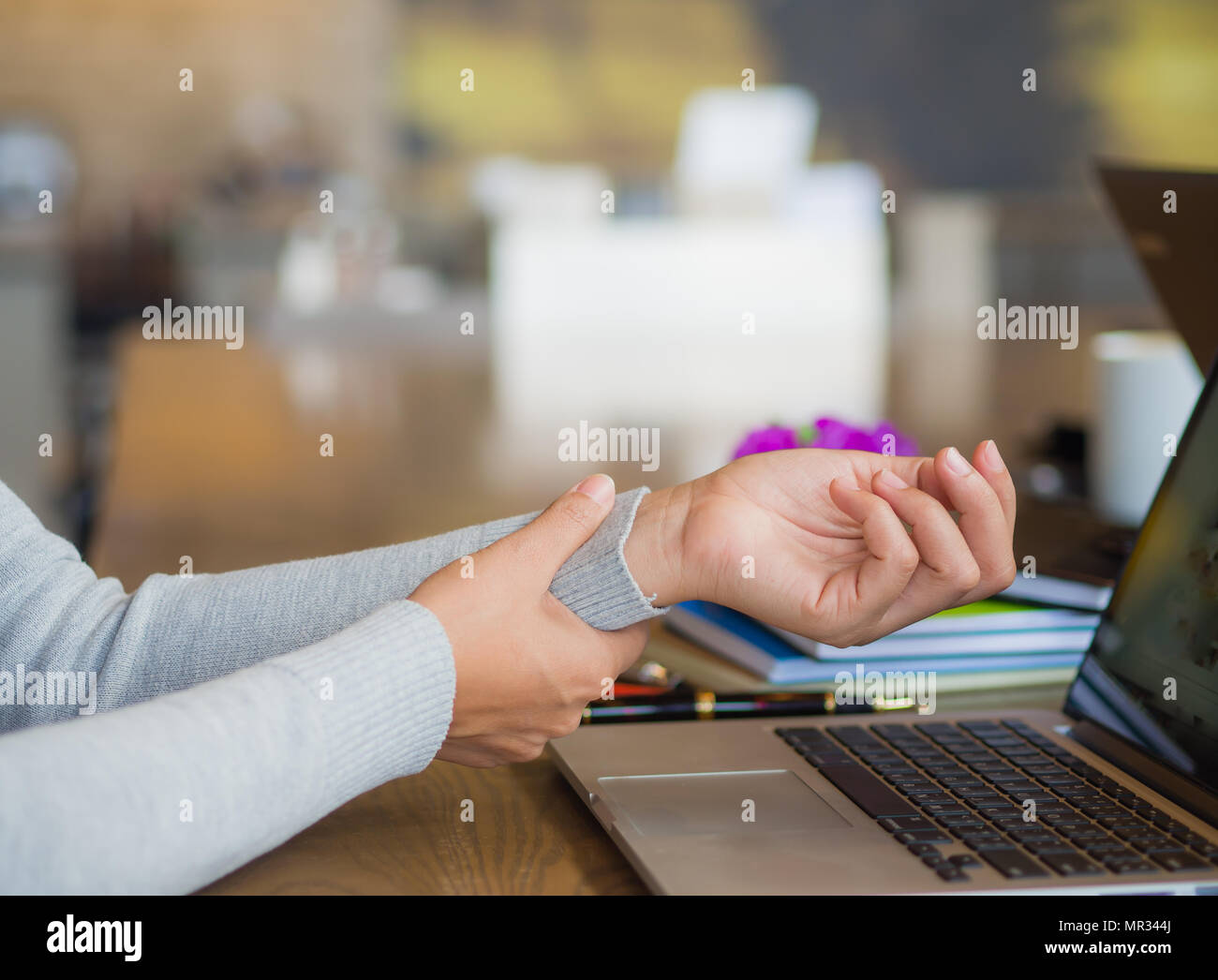 Closeup woman holding her wrist pain from using computer long time ...