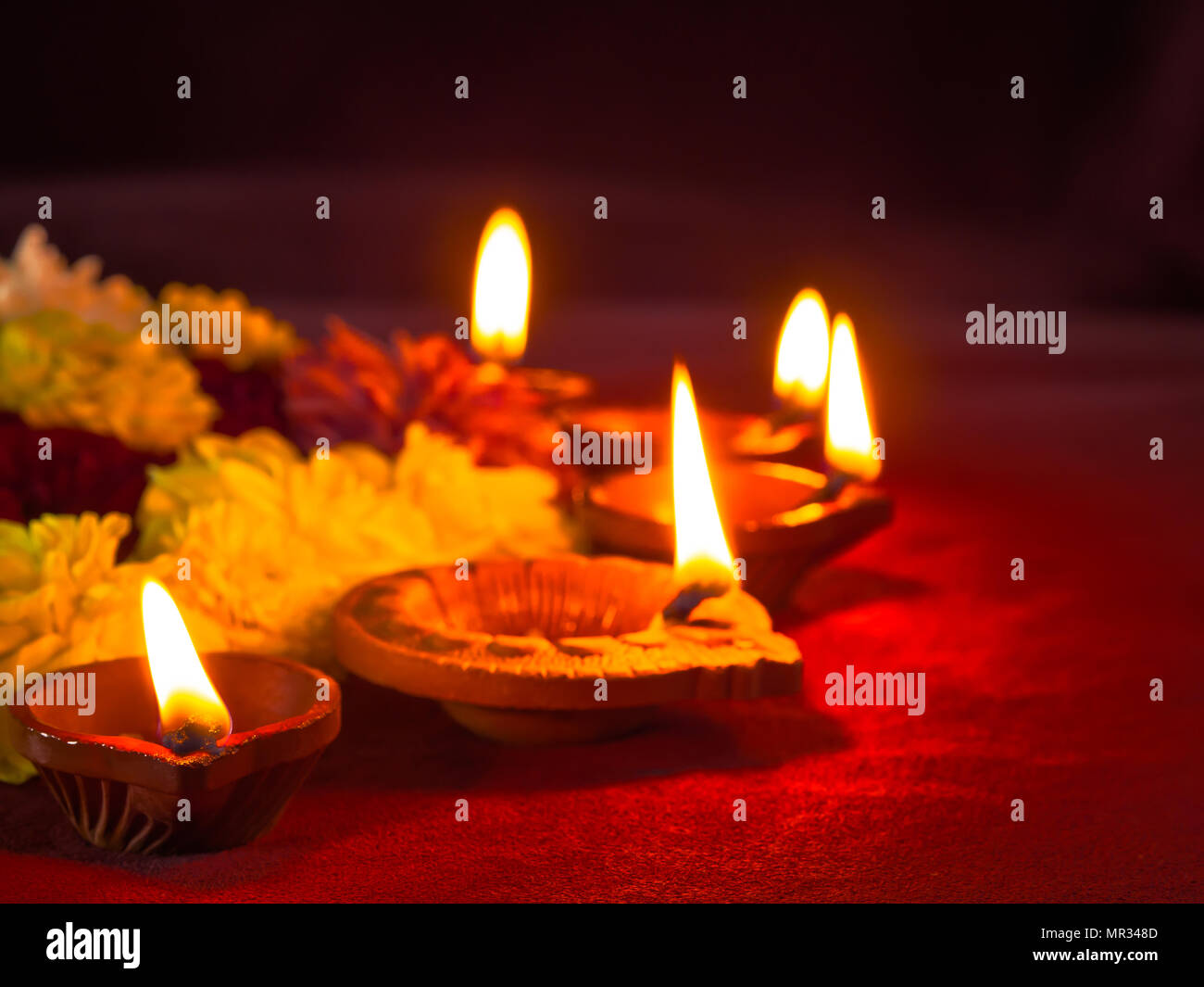 Traditional clay diya lamps lit with flowers for Diwali festival ...