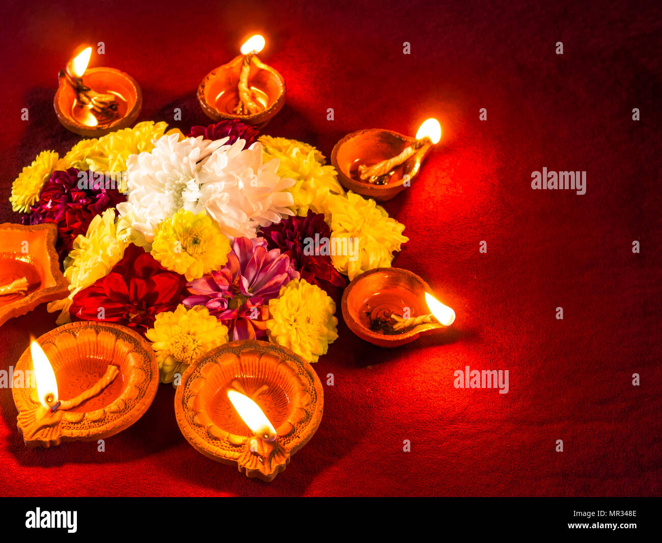 Traditional clay diya lamps lit with flowers for Diwali festival ...